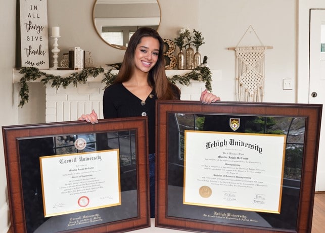 Woman with two different sized diploma frames